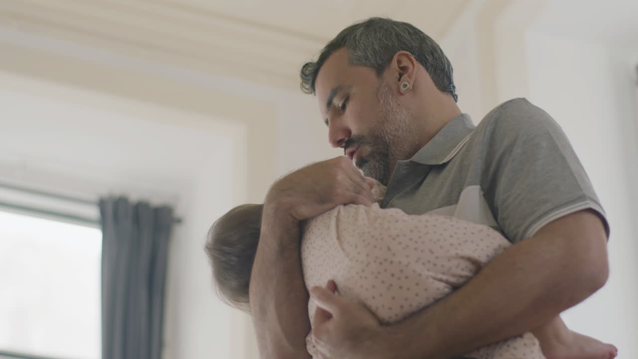 Premium stock video - Loving dad cradling his cute baby girl in his ...