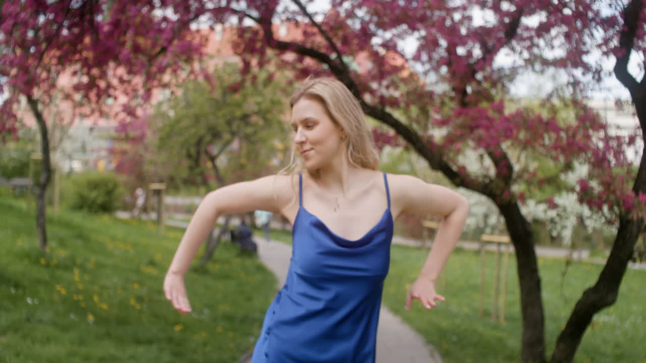 Free stock video - Blonde woman dancing alone in a park