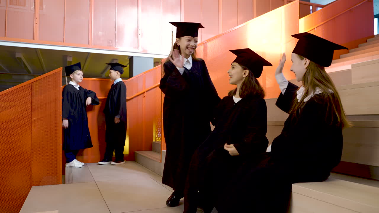 Premium stock video - Happy kindergarten students in cap and gown ...