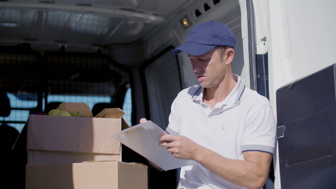 Premium stock video - Concentrated delivery man sitting in van and ...