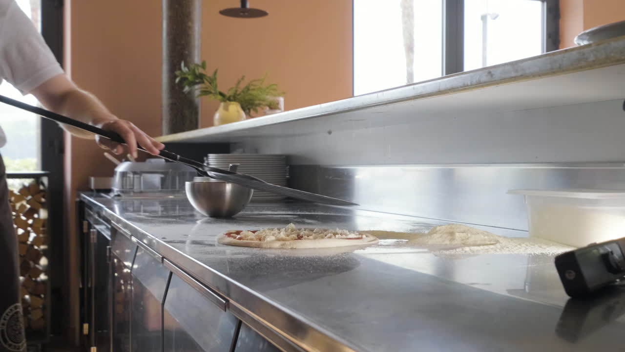 Premium stock video - Chef holding pizza on a tray in restaurant kitchen