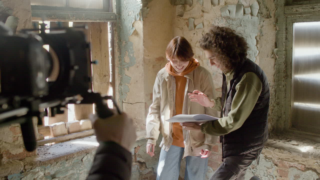 Premium stock video - Coworkers reading a script in a ruined building ...
