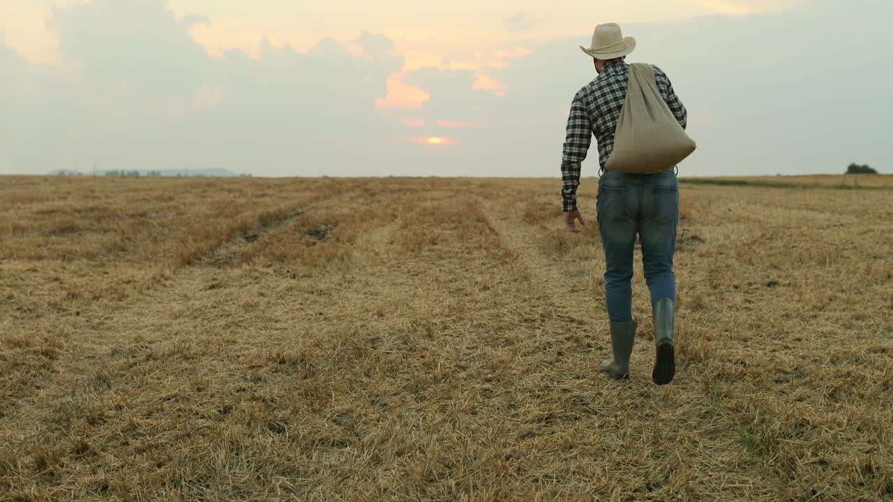 Free stock video - Back view of farmer wearing a hat abd carrying a ...