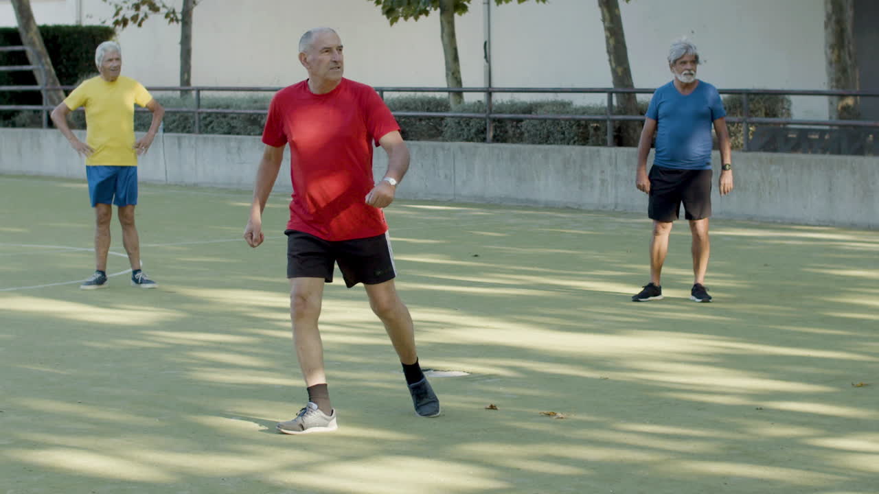 Free stock video - Long shot of a focused senior man kicking ball while ...