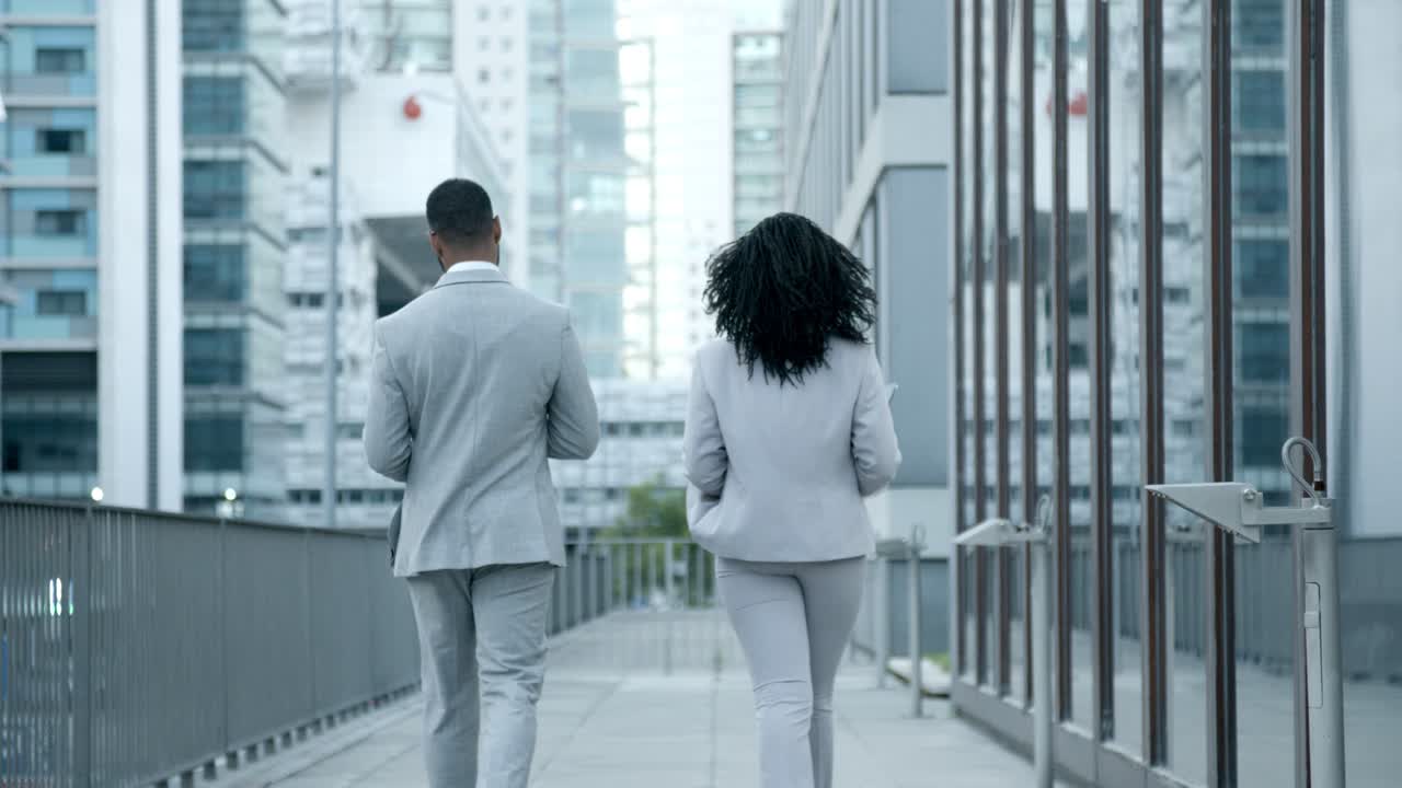 Free stock video - Back view of two managers walking near office building