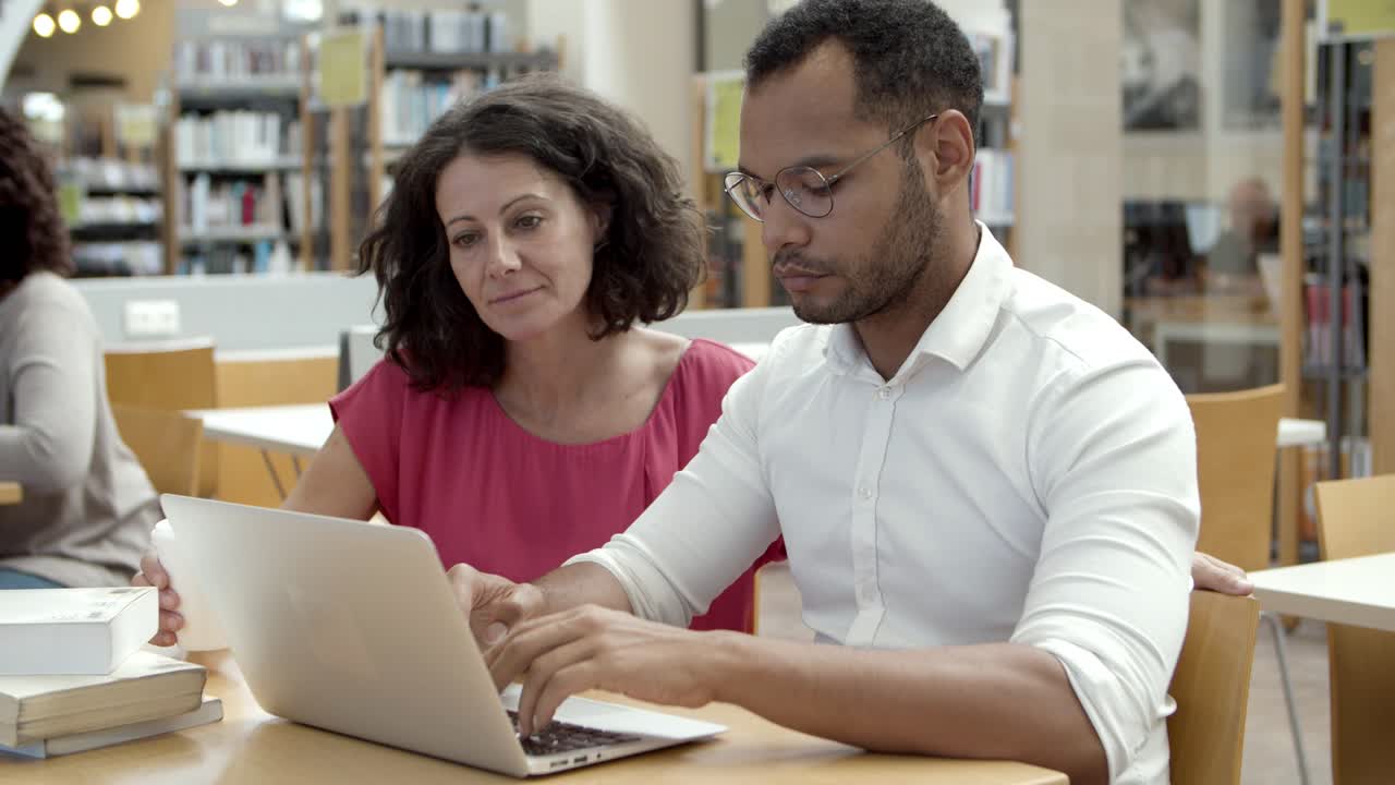 Free stock video - Smiling students studying at public library