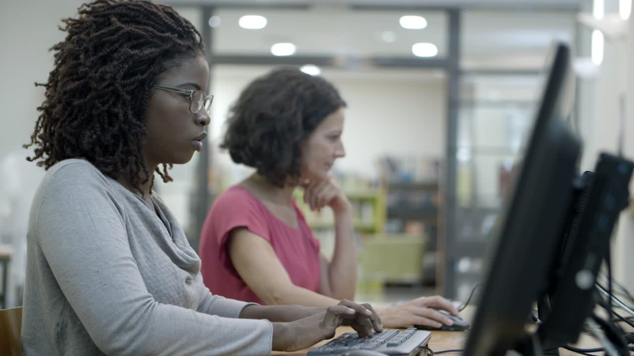 Free stock video - Side view of two women working with computers