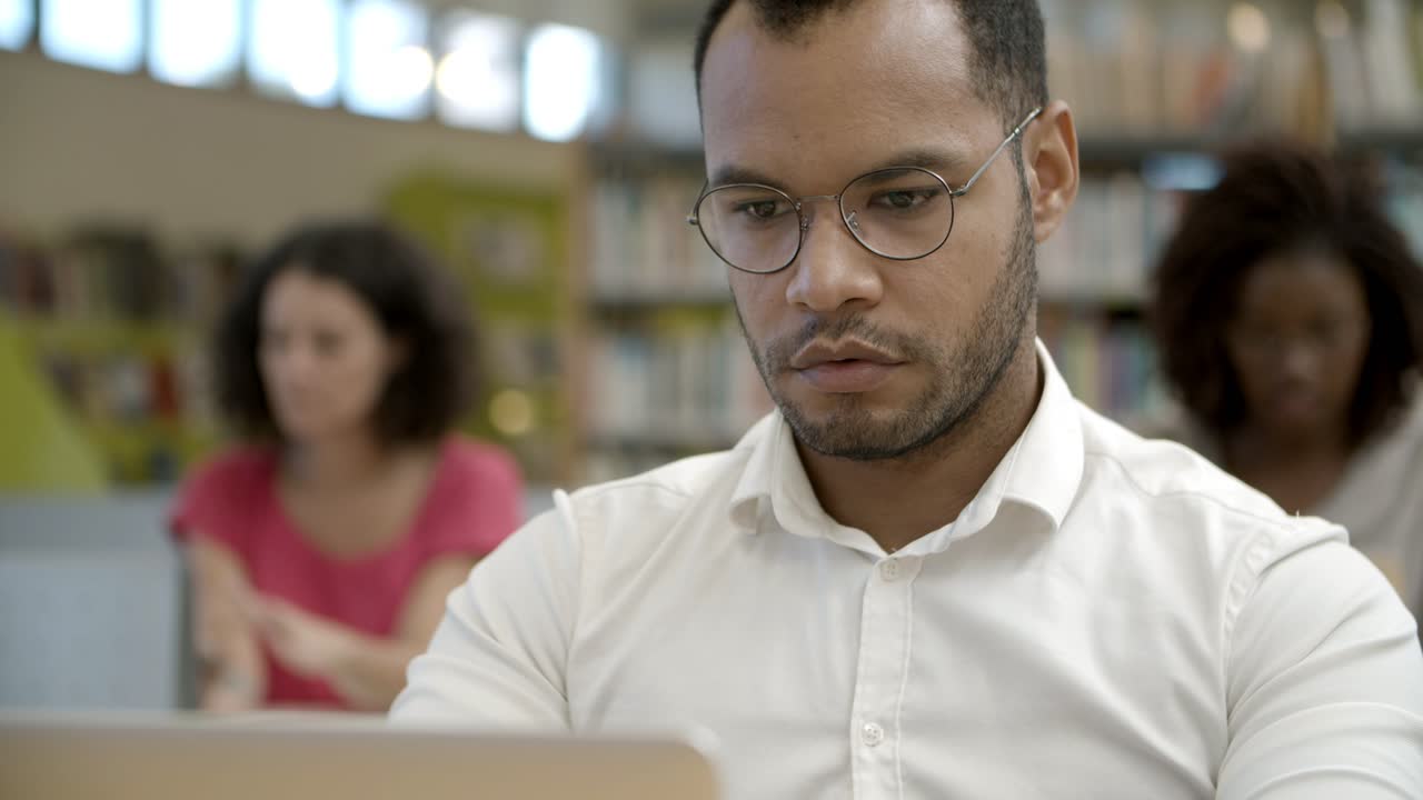 Free stock video - Closeup shot of focused young man using laptop at ...