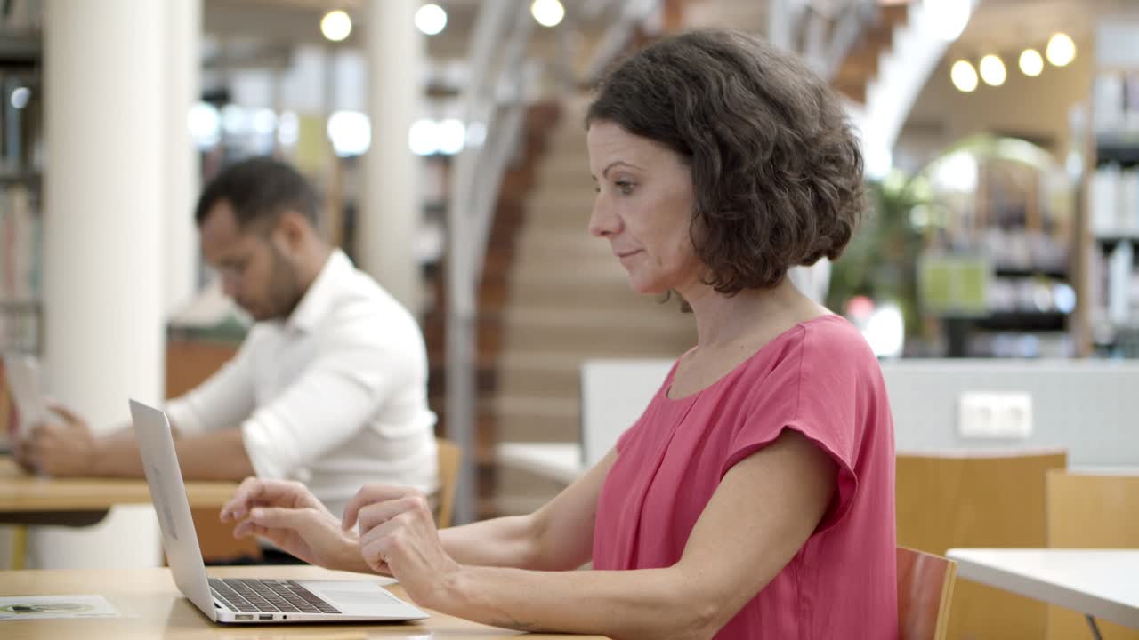 Free stock video - Side view of pensive caucasian woman using laptop