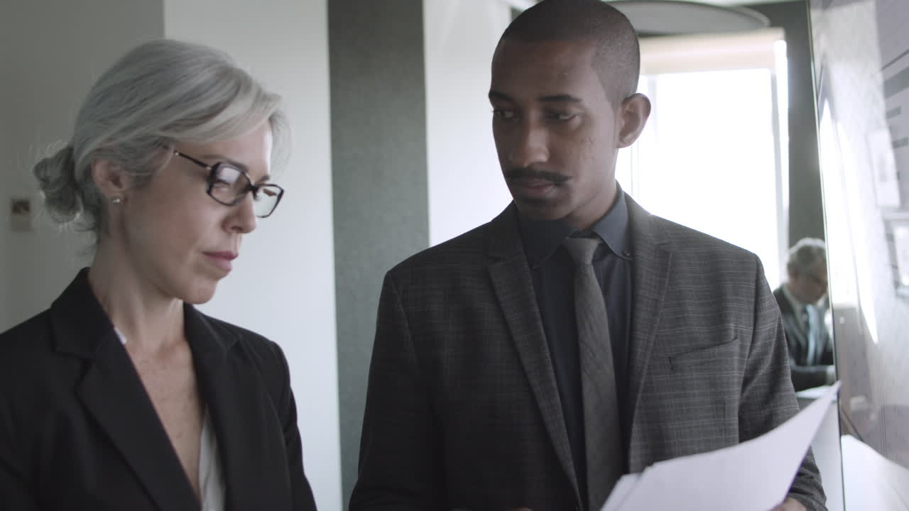 Free stock video - Financial experts discussing trading graphs