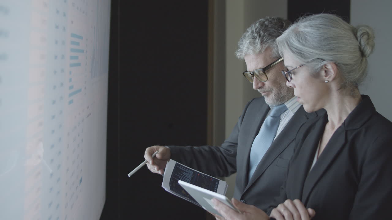 Free stock video - Finance professionals looking at stock market statistics