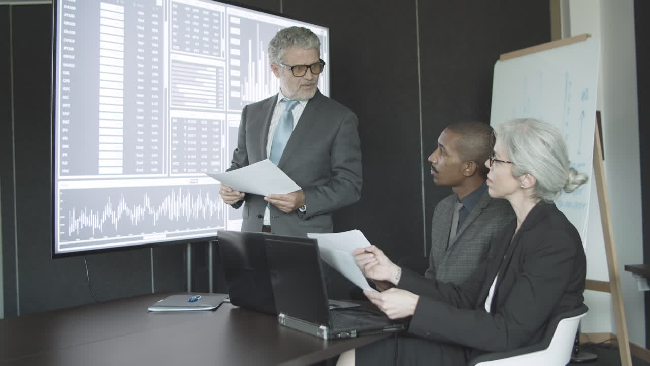 Free stock video - Mentor explaining financial diagrams to interns