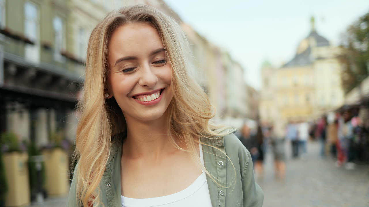 Free stock video - Close-up view of caucasian blonde woman looking straight to the camera while ...