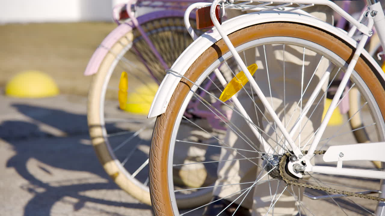 Free stock video - Close-up view of the wheel of a white bicycle turning