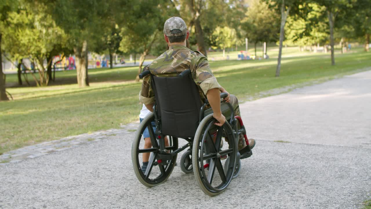 Free stock video - Disabled soldier walking with kids in park