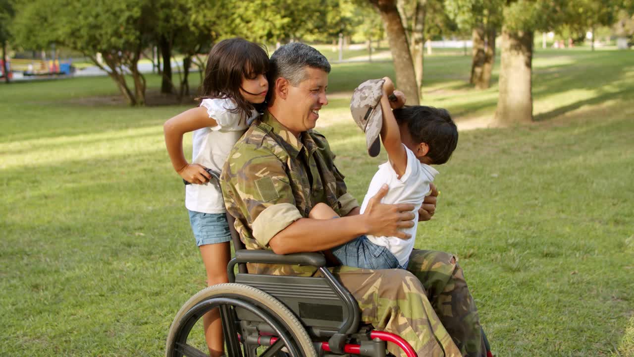 Free stock video - Disabled military dad playing with kids in park