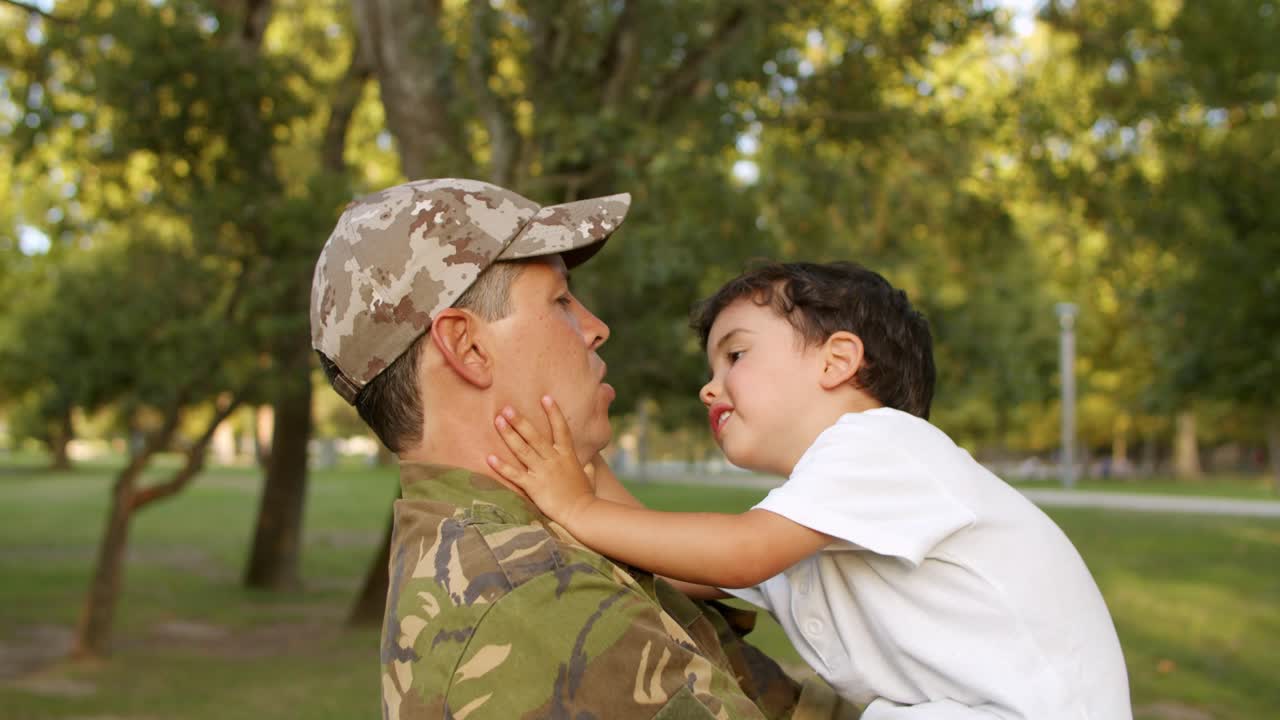 Free stock video - Strong military daddy holding little son in arms