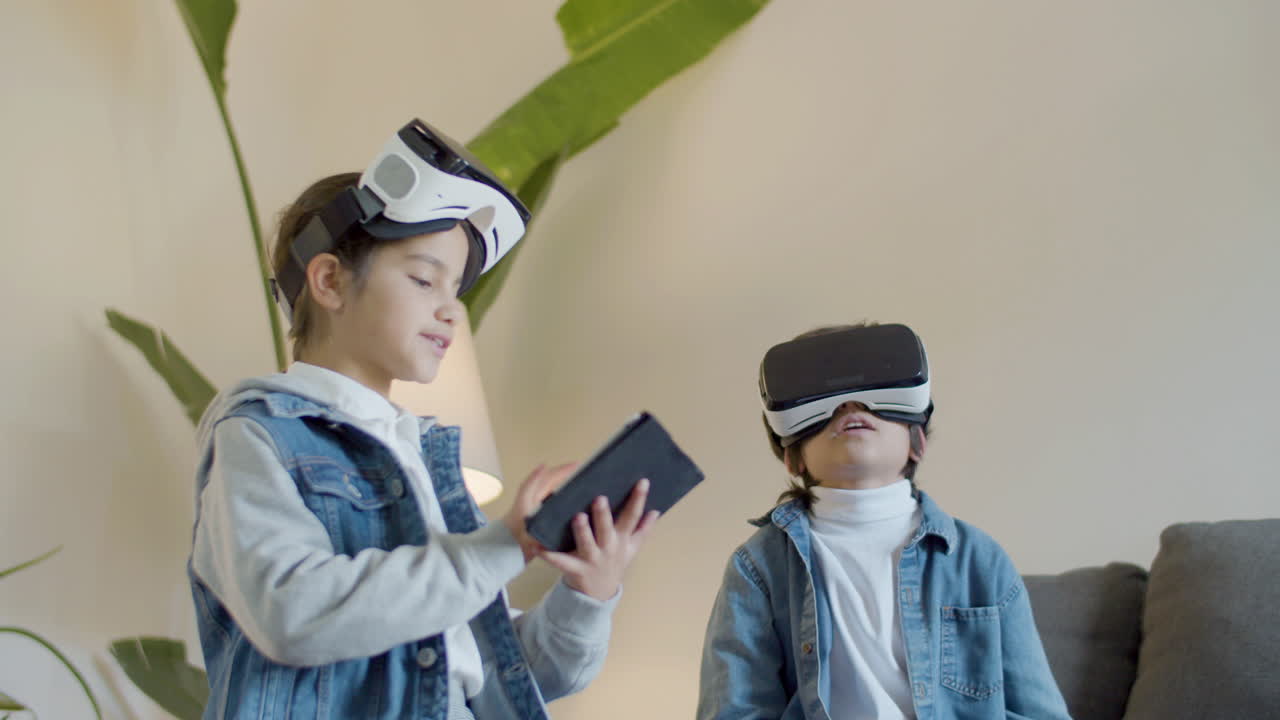 Free stock video - Two kids having fun playing with virtual reality glasses