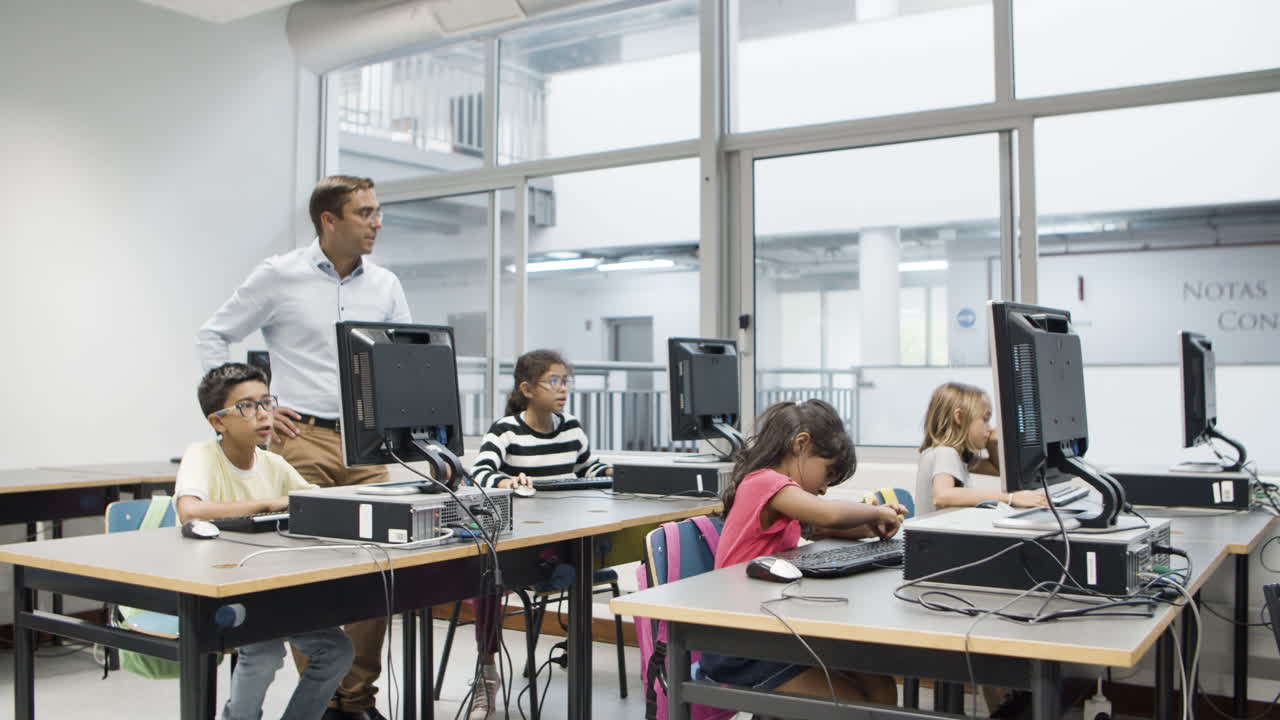 Free stock video - Computer science teacher watching as pupils doing task