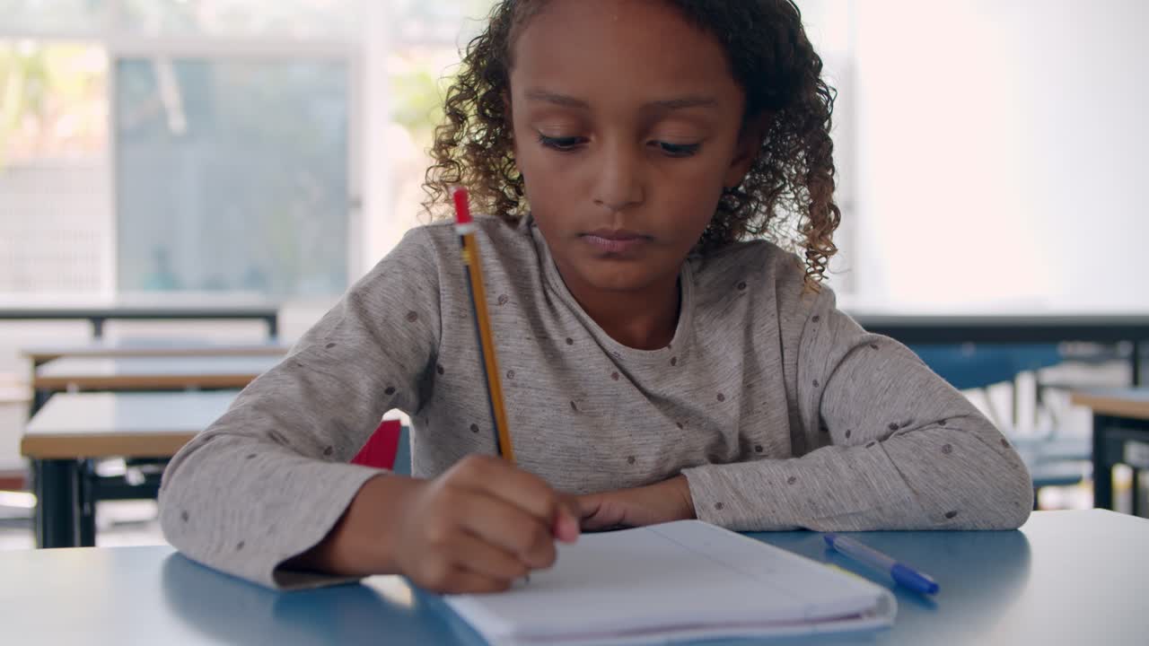 Free stock video - African american girl doing homework in class