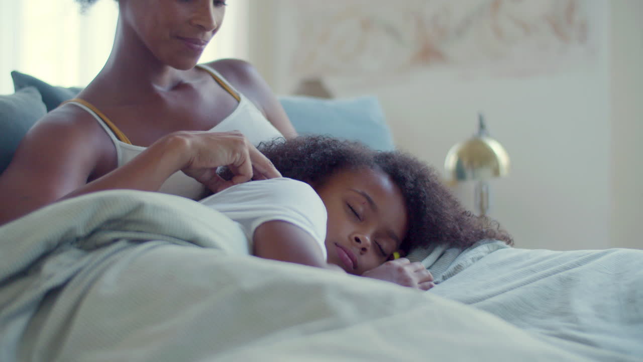 Free Stock Video Close Up Of Little Black Girl Lying On Her Mums Knees In Bed Then Opening