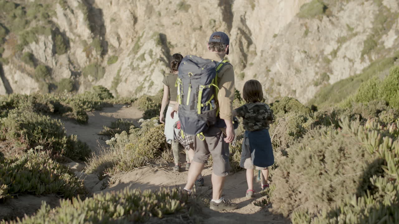 Free stock video - Family of backpackers descending steep mountain slope