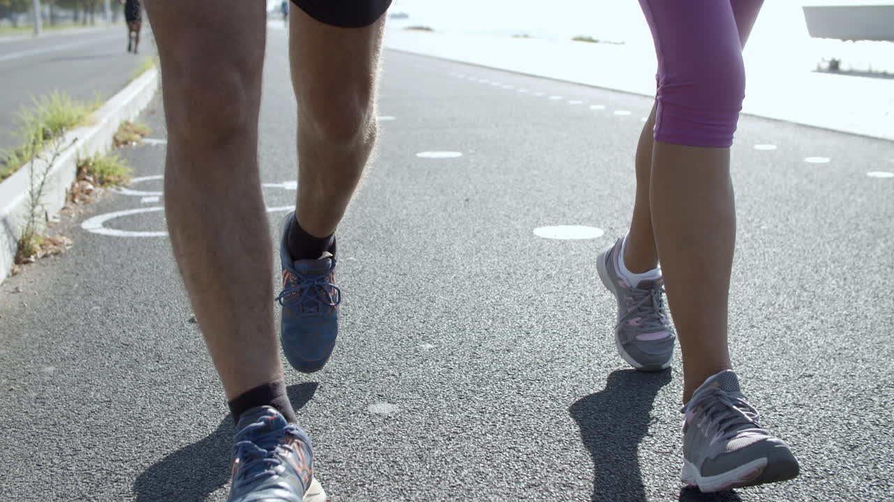Free stock video - Male and female legs running on asphalt road