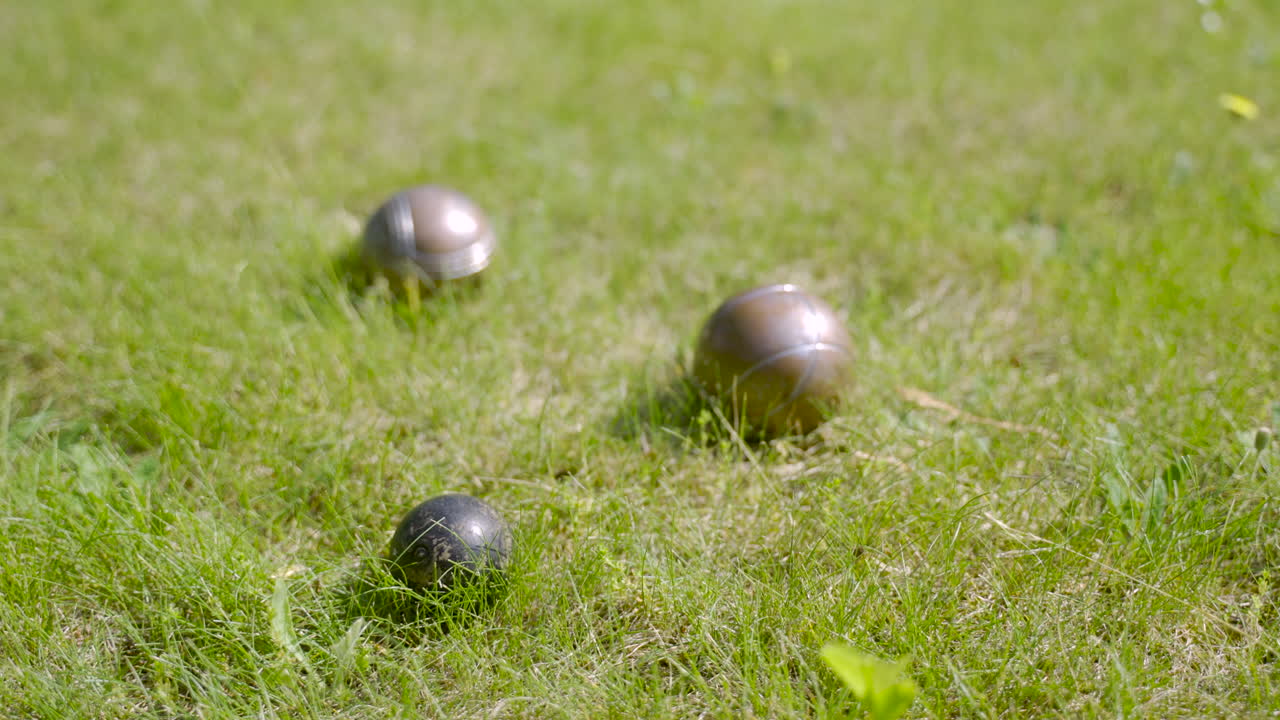Free stock video - Close-up view of three metal petanque balls on the ...