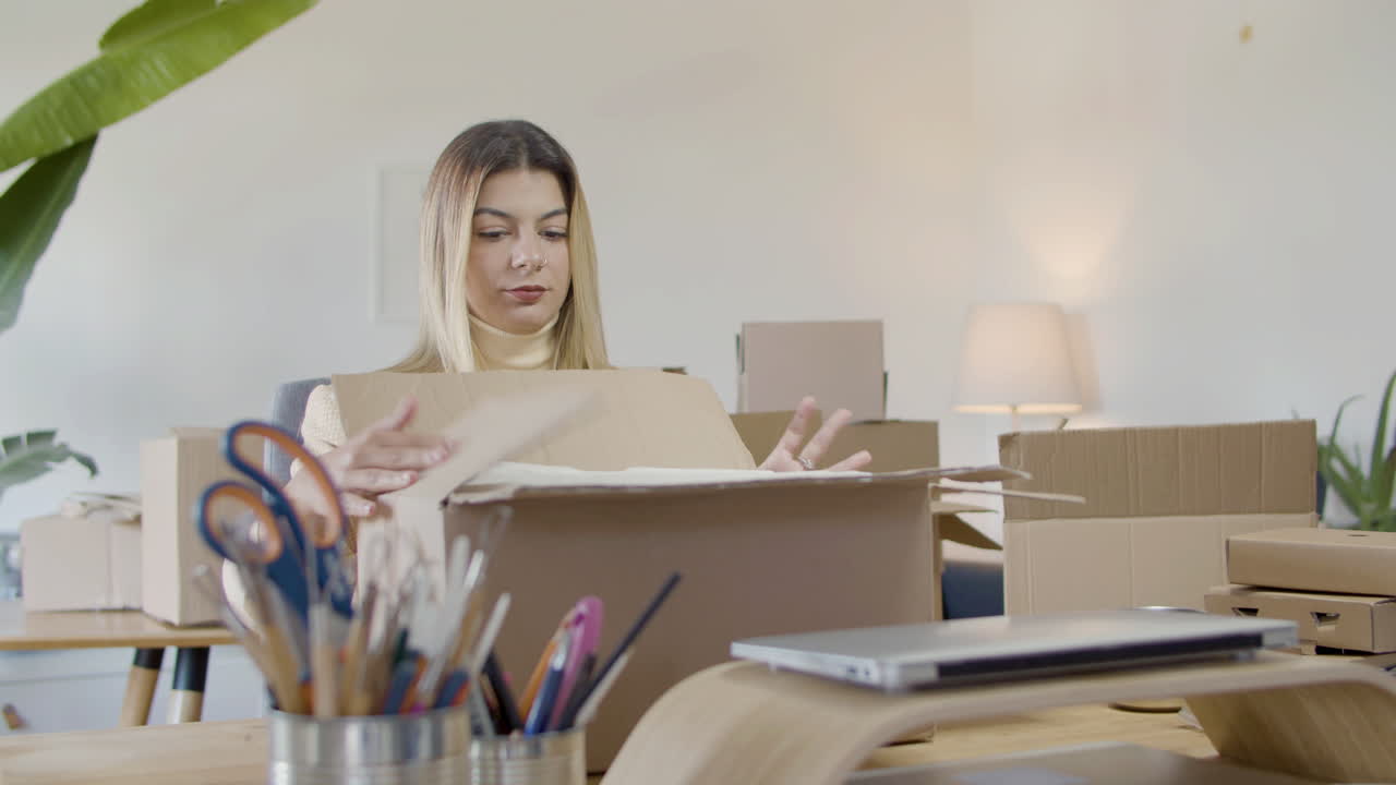 Free stock video - Young caucasian lady packing goods in cardboard parcel