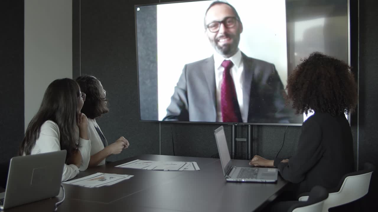 Vídeo Gratis - Jefe de mediana edad saludando a los empleados a través ...