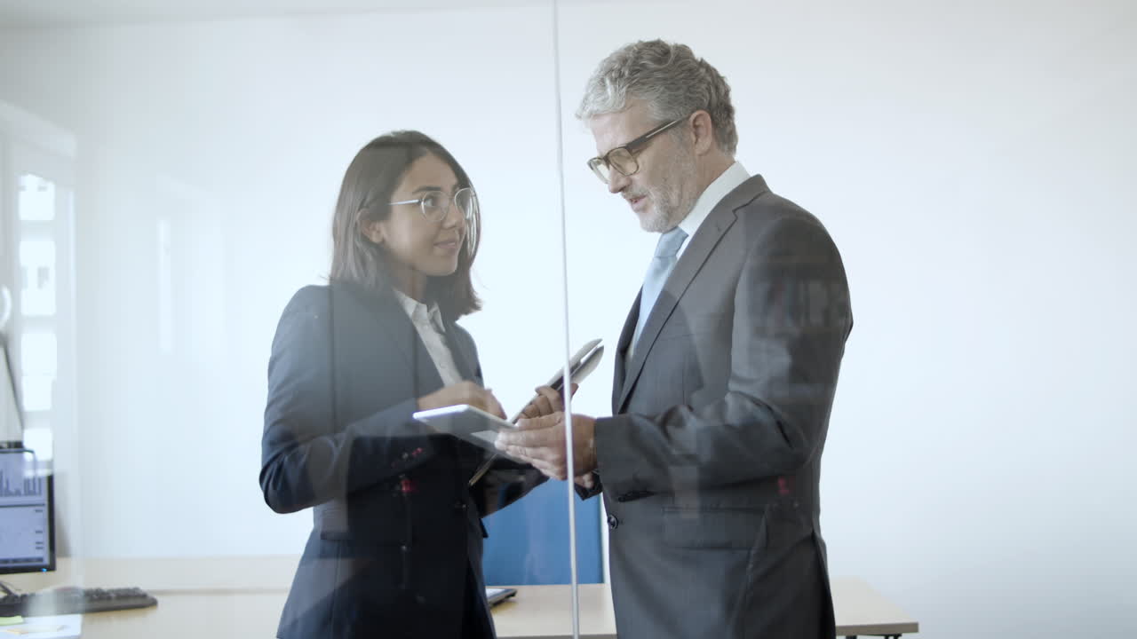 Free stock video - Focused mature businessman consulting young female ...