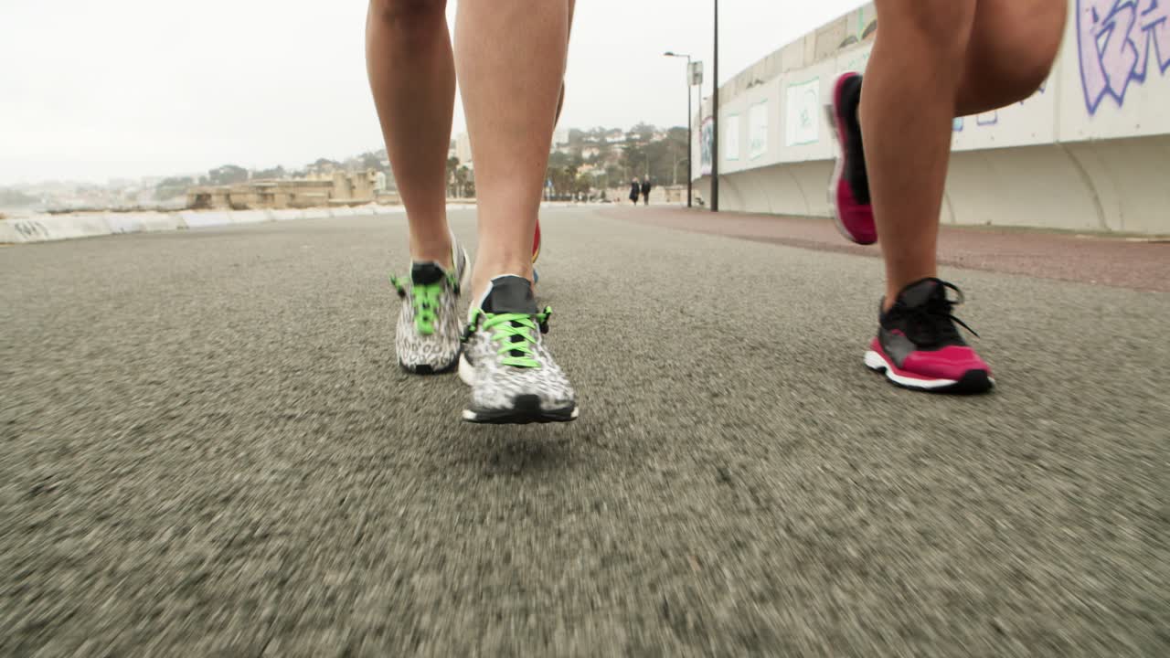 Free stock video - Ankles and feet of athletes jogging along road