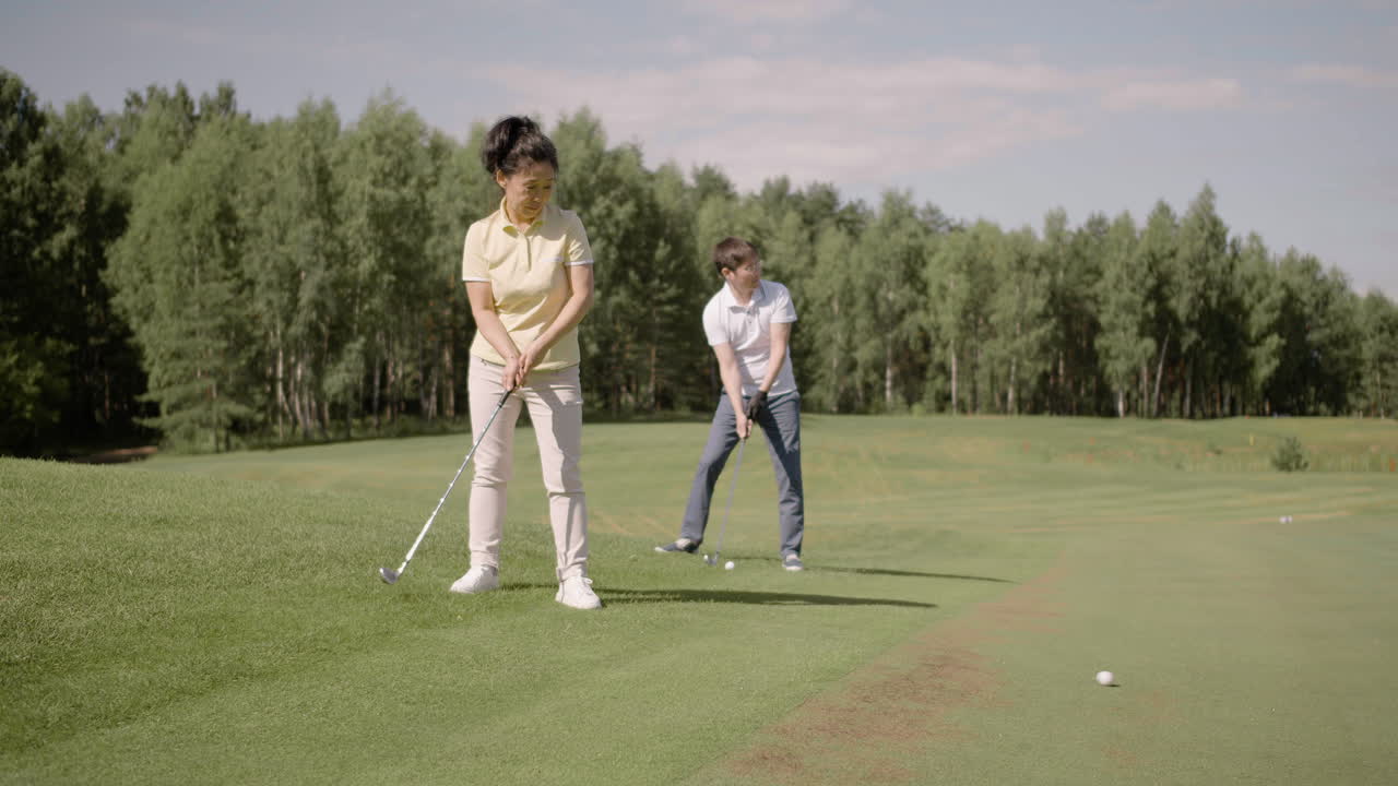 Vídeo Gratis Jugadores De Golf Con Palos De Golf En Campo De Hierba Cerca De Bosques