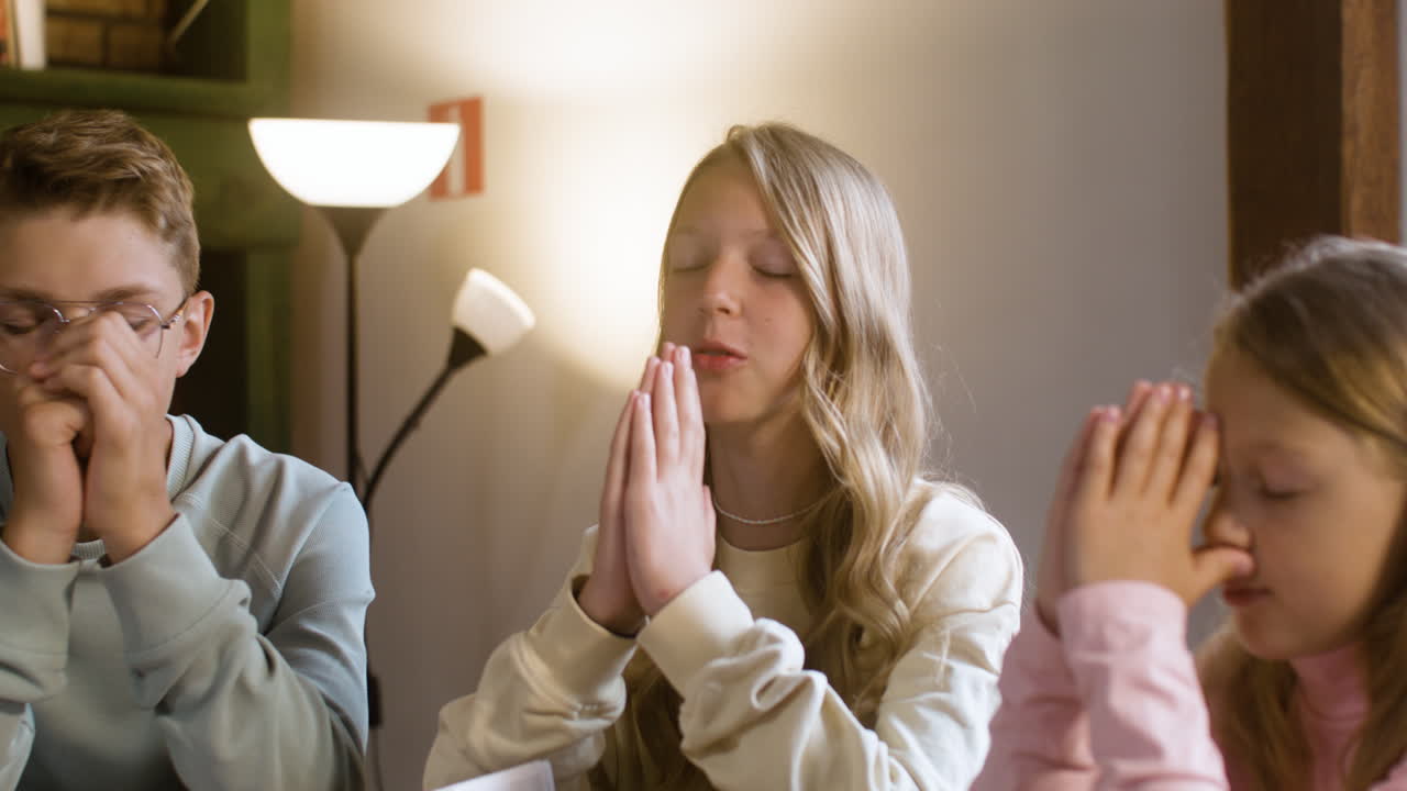 Free stock video - Blond girl praying out loud next to her classmates