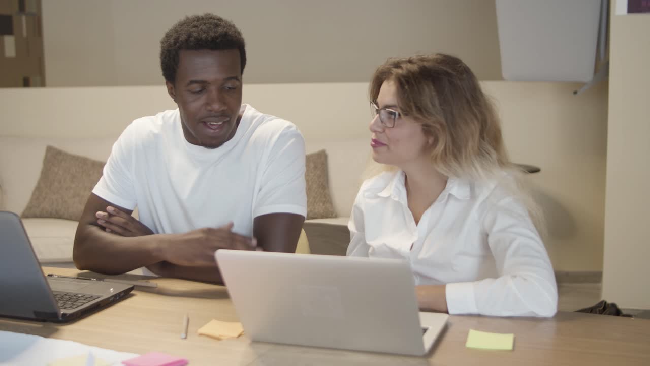 Free stock video - Two project managers sitting at table with laptops