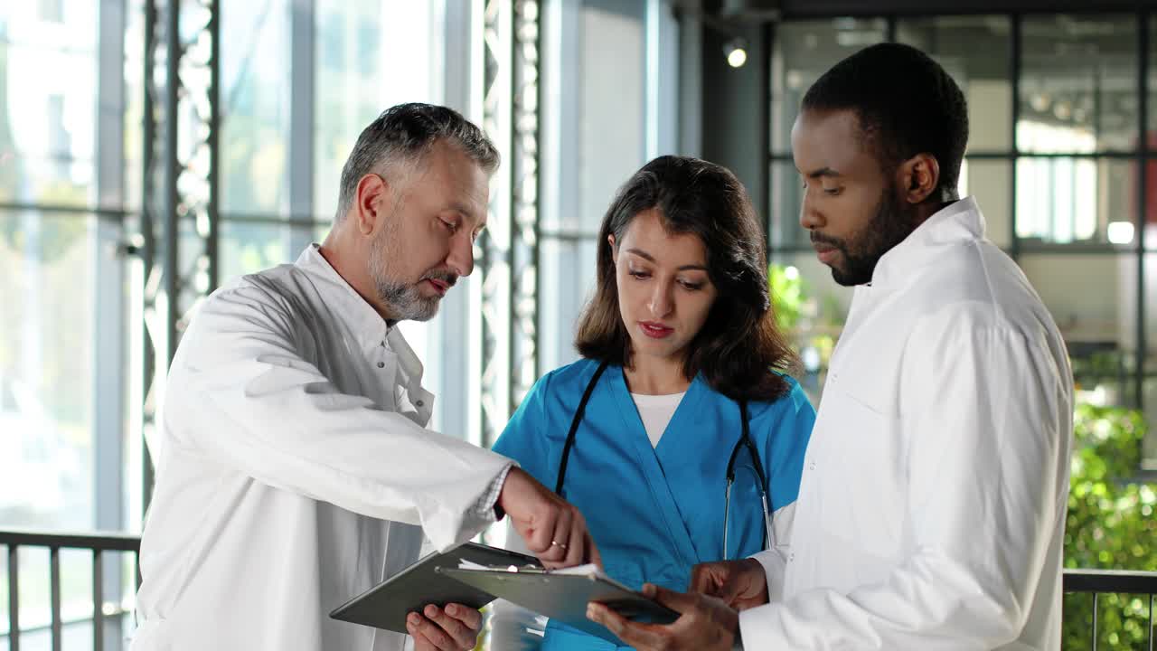 Free stock video - Multi-ethnic male and female doctors talking in clinic