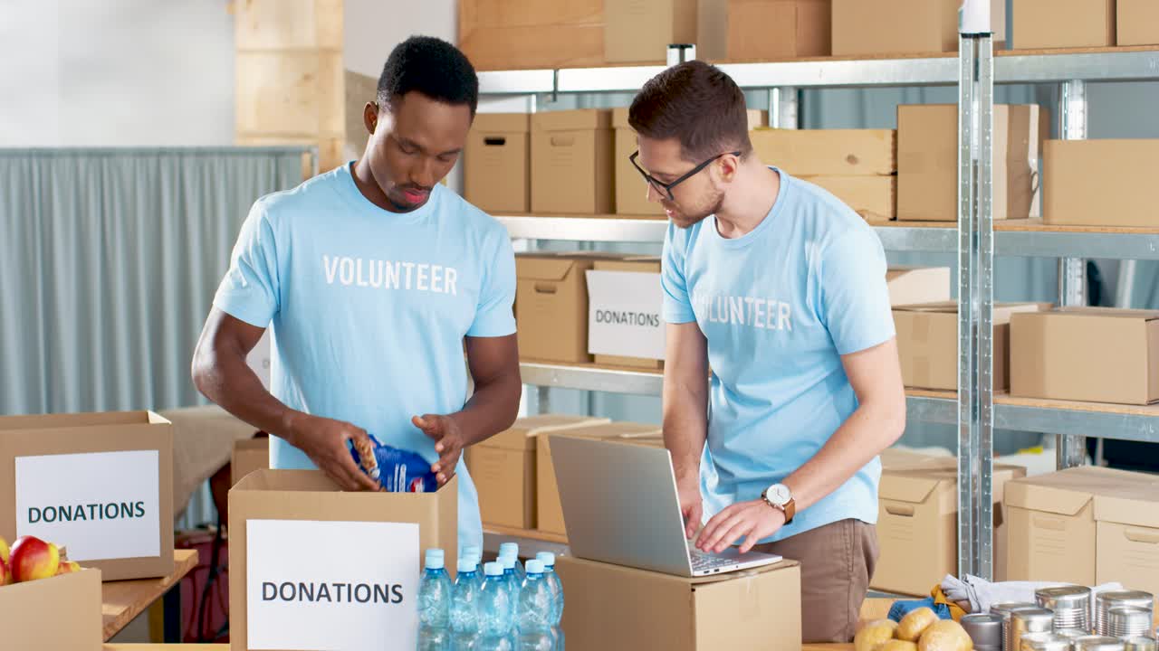 Free stock video - African american male volunteer packing donation box ...