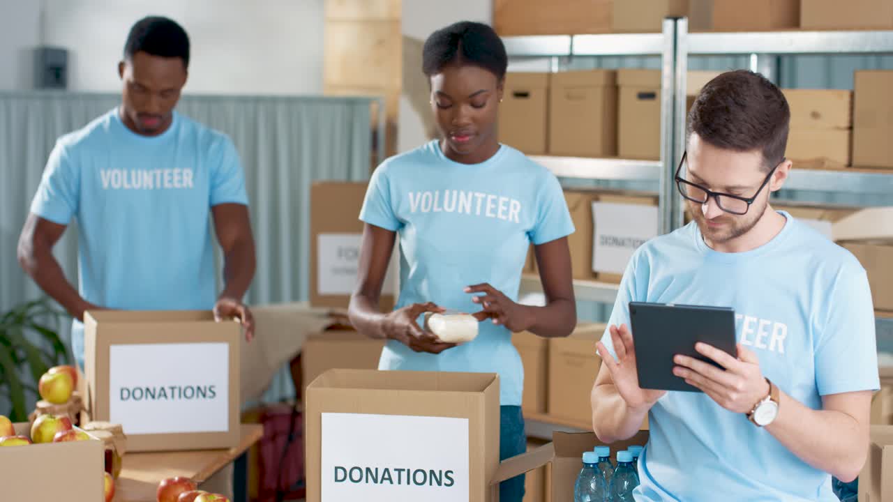 Free stock video - Multiethnic group of volunteers packing boxes with ...