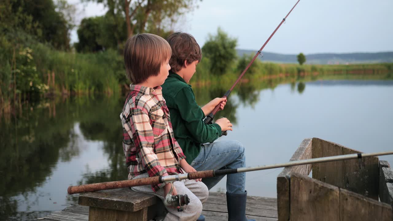 Free stock video - Side view of two teen boys sitting on the lake pier ...