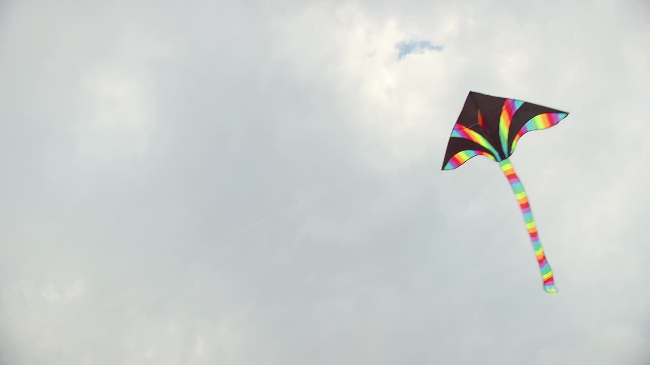 Free stock video - Low angle view of a colorful kite flying in the blue sky