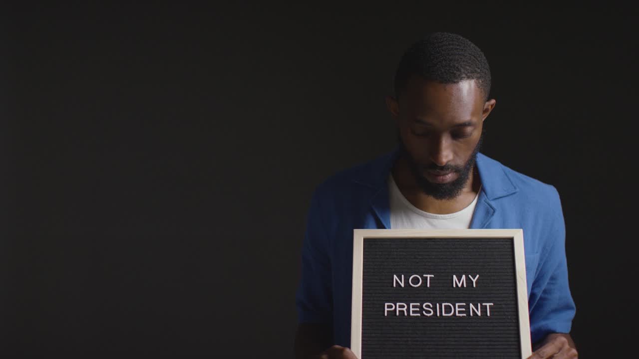 Free stock video - Portrait of man holding not my president sign in ...