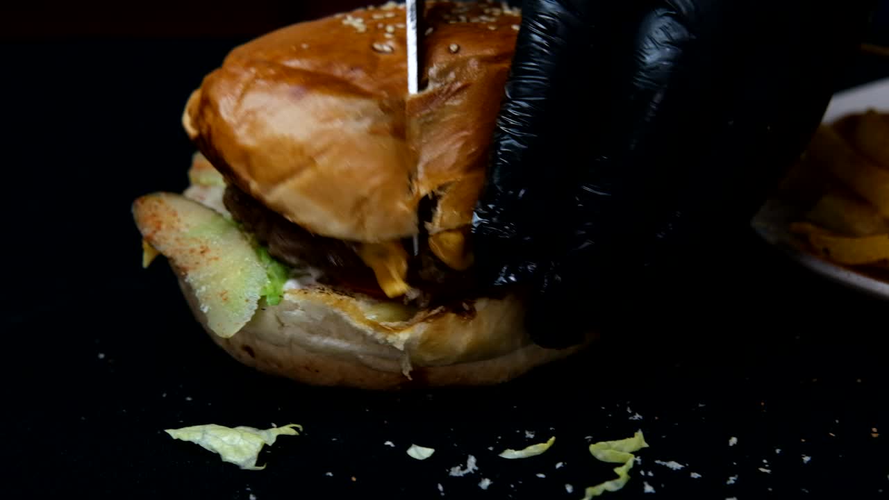 Premium stock video - Cuting burger with knife