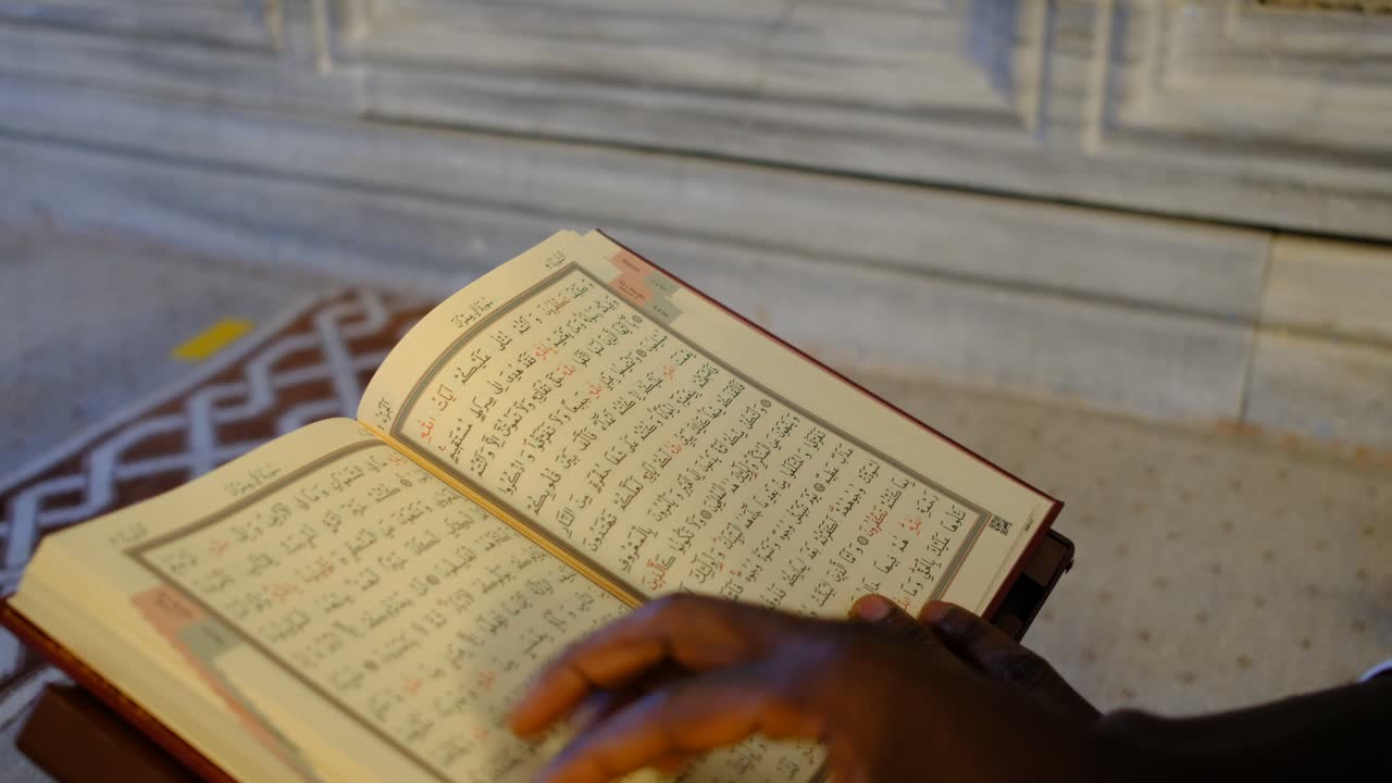 Premium stock video - Reading quran on table