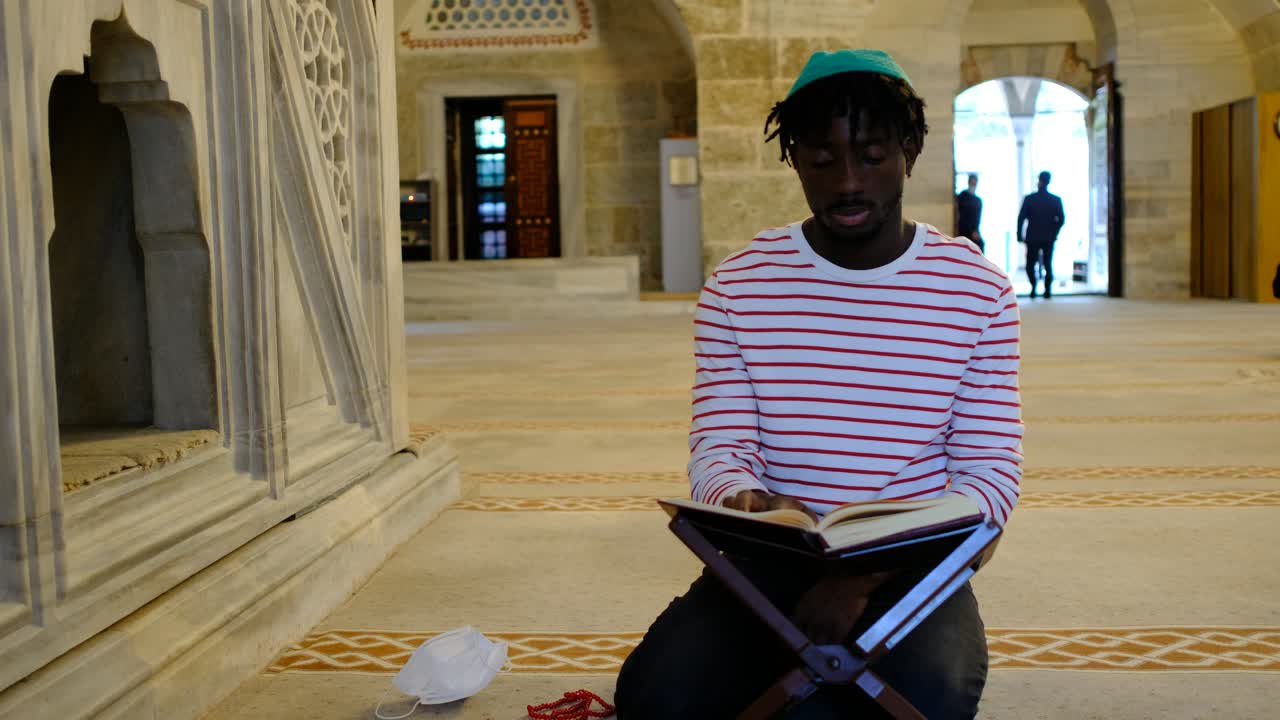 Premium stock video - Muslim african man reading quran