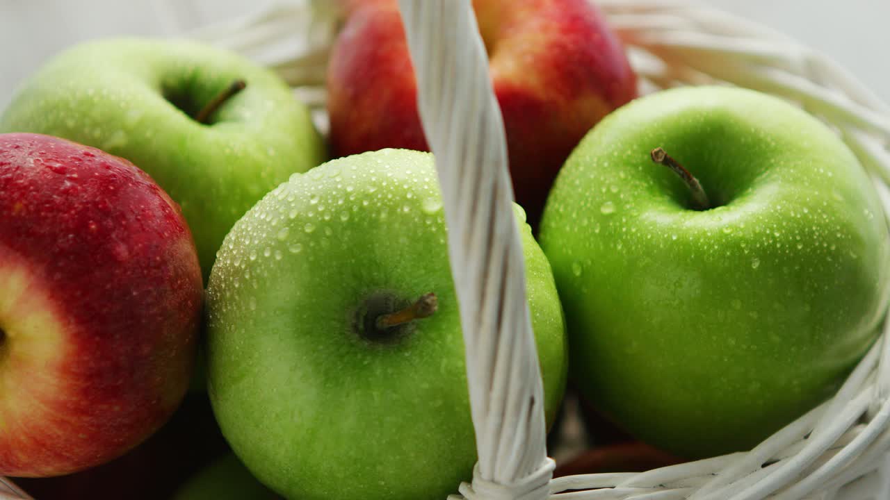 Premium stock video - Mixed green and red apples in basket