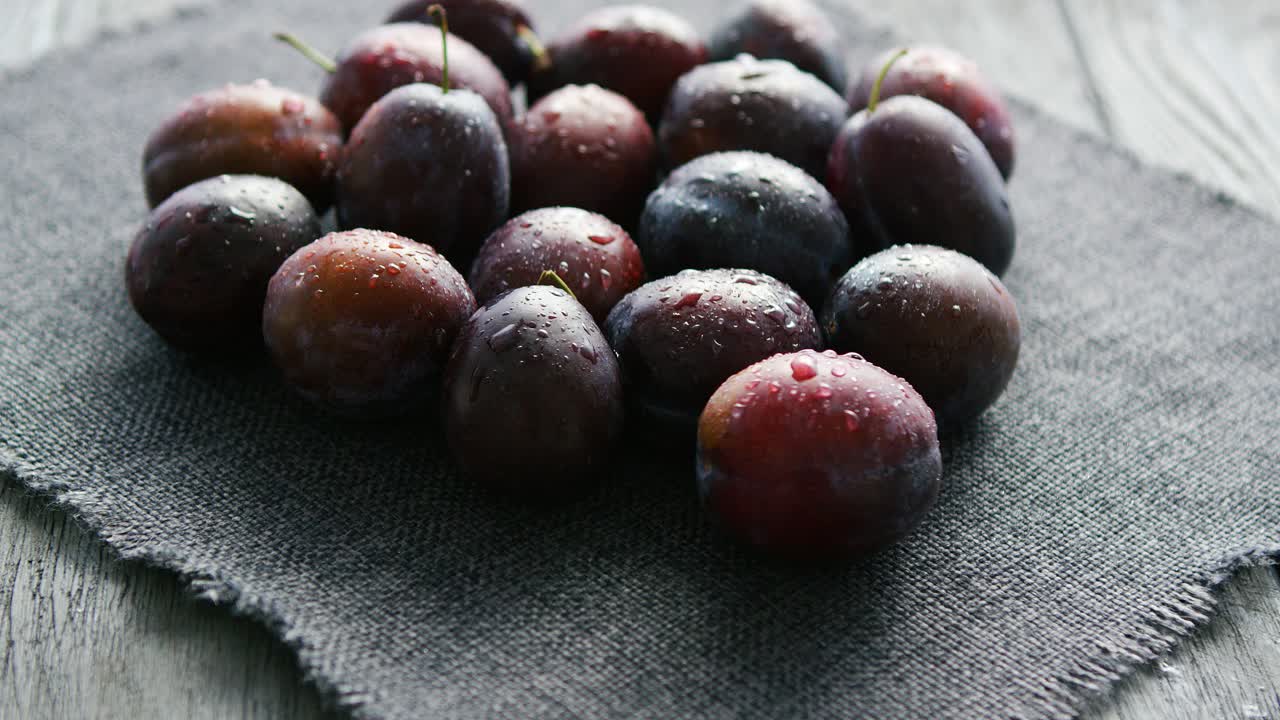 Premium stock video - Wet fresh plums on napkin