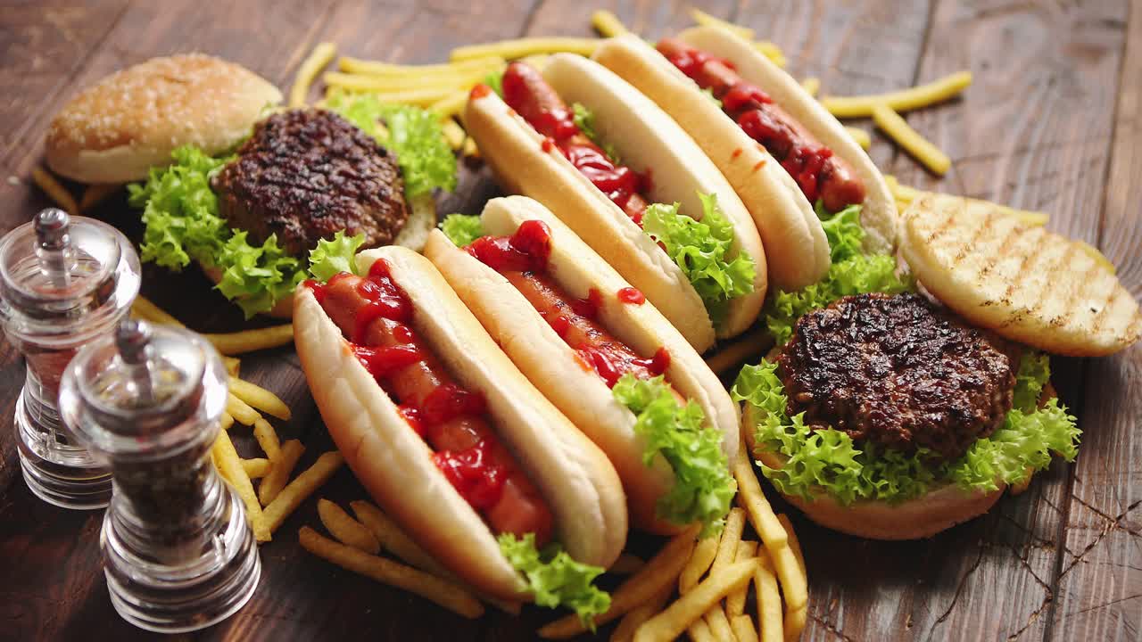 Premium stock video - Hot dogs hamburgers and french fries composition ...