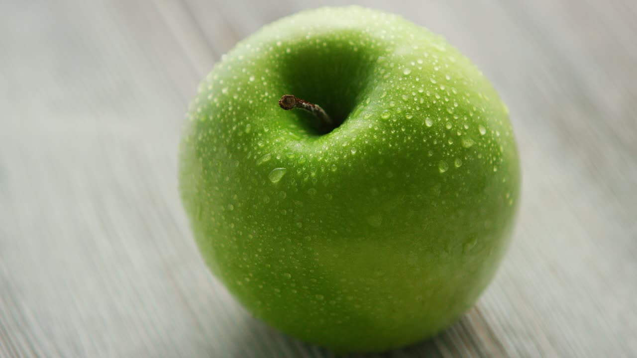 Premium stock video - Green ripe apple with water drops