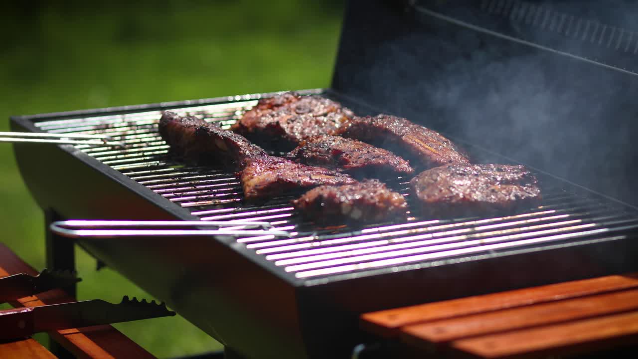 Premium stock video - Tasty ribs cooking on barbecue grill for summer ...