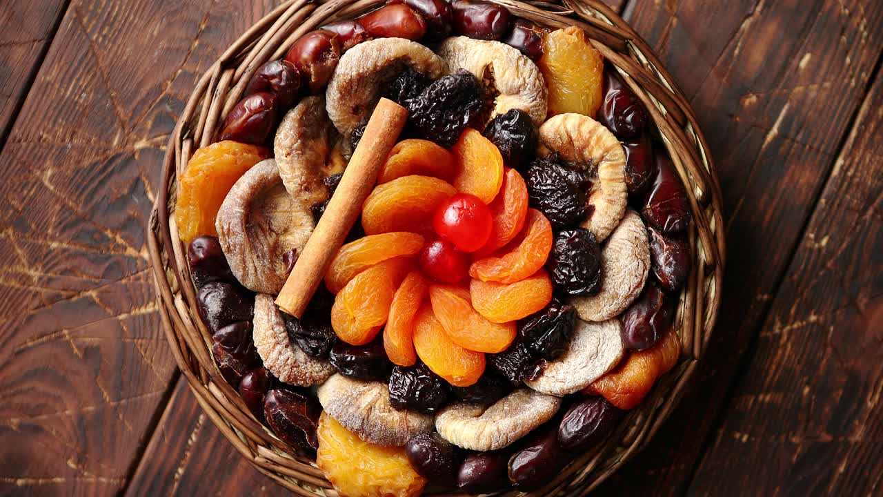 Premium stock video - Mix of dried fruits in a small wicker basket on ...